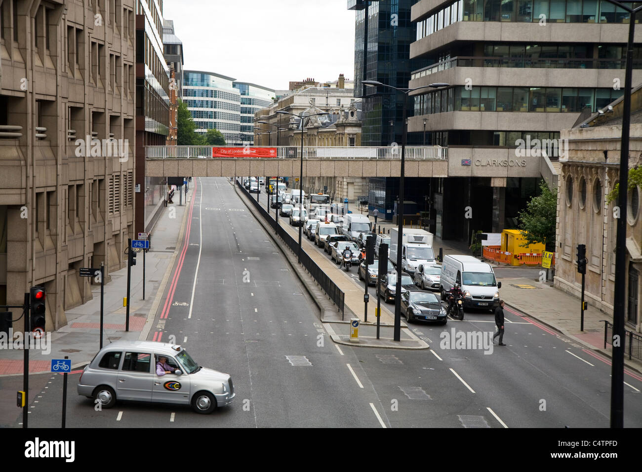Taxi turning right across London – bound morning commuter traffic ...