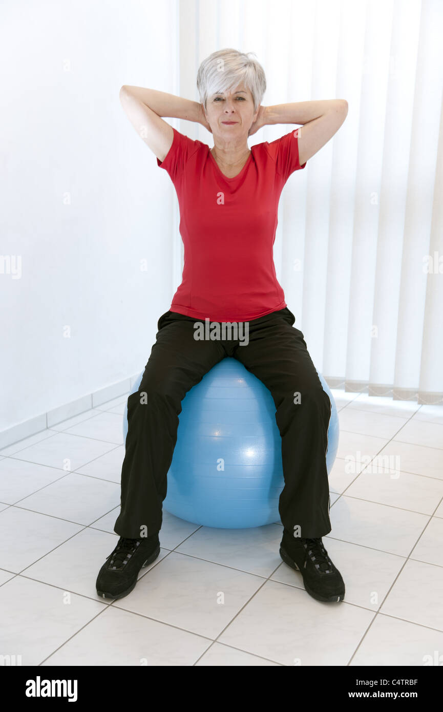 Woman, 50 +, sitting on a stability ball Stock Photo - Alamy