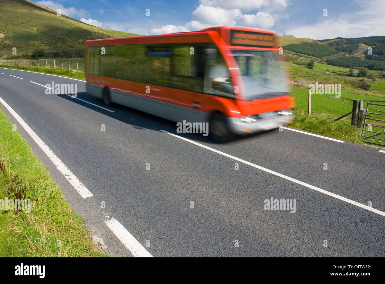 Red bus on rural road in Wales Stock Photo - Alamy