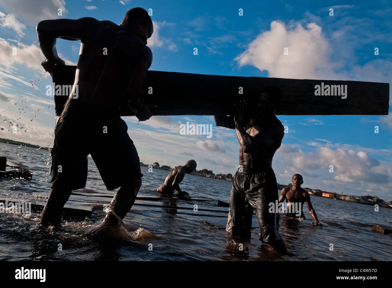 Colombian workers transport timbers from the Pacific rainforest at a ...