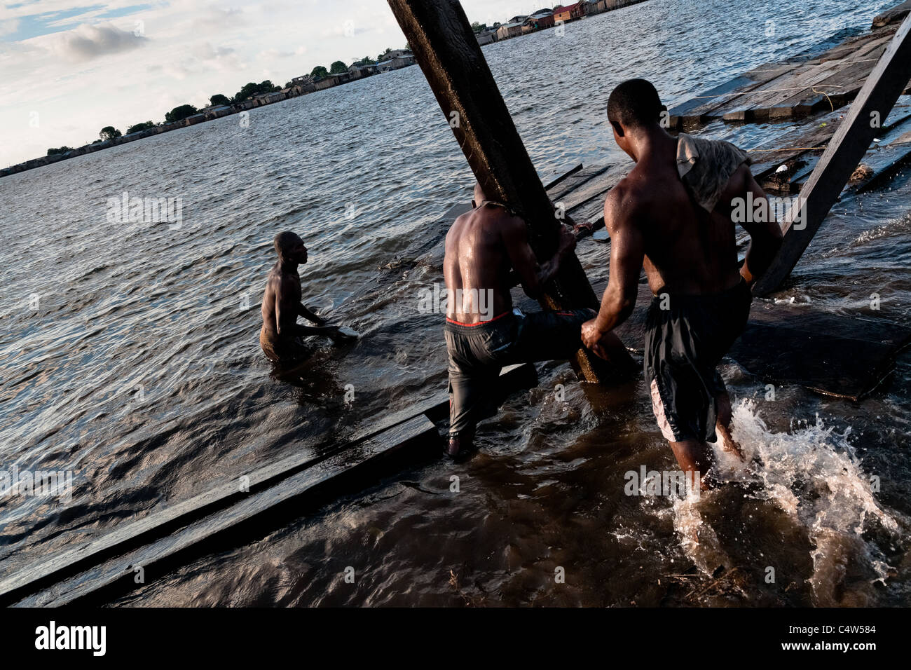 Colombian workers transport lumbers from the Pacific rainforest at a ...