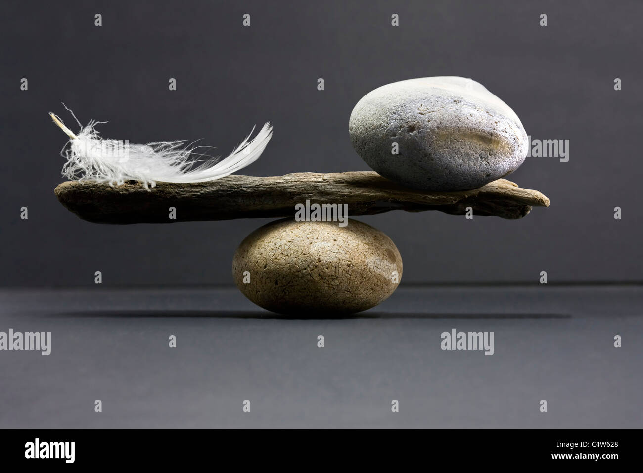 a feather and a stone equally balance Stock Photo - Alamy