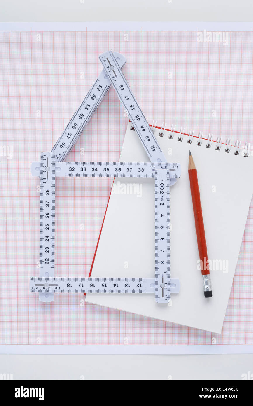 Folding Ruler in Shape of House with Pencil and Notepad Stock Photo - Alamy