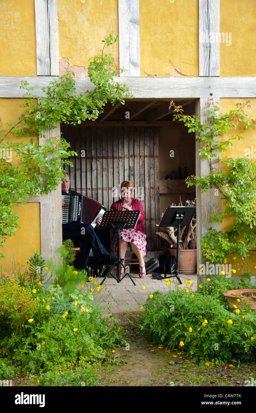 Musicians: accordian and oboeist players, within a timber framed folly ...