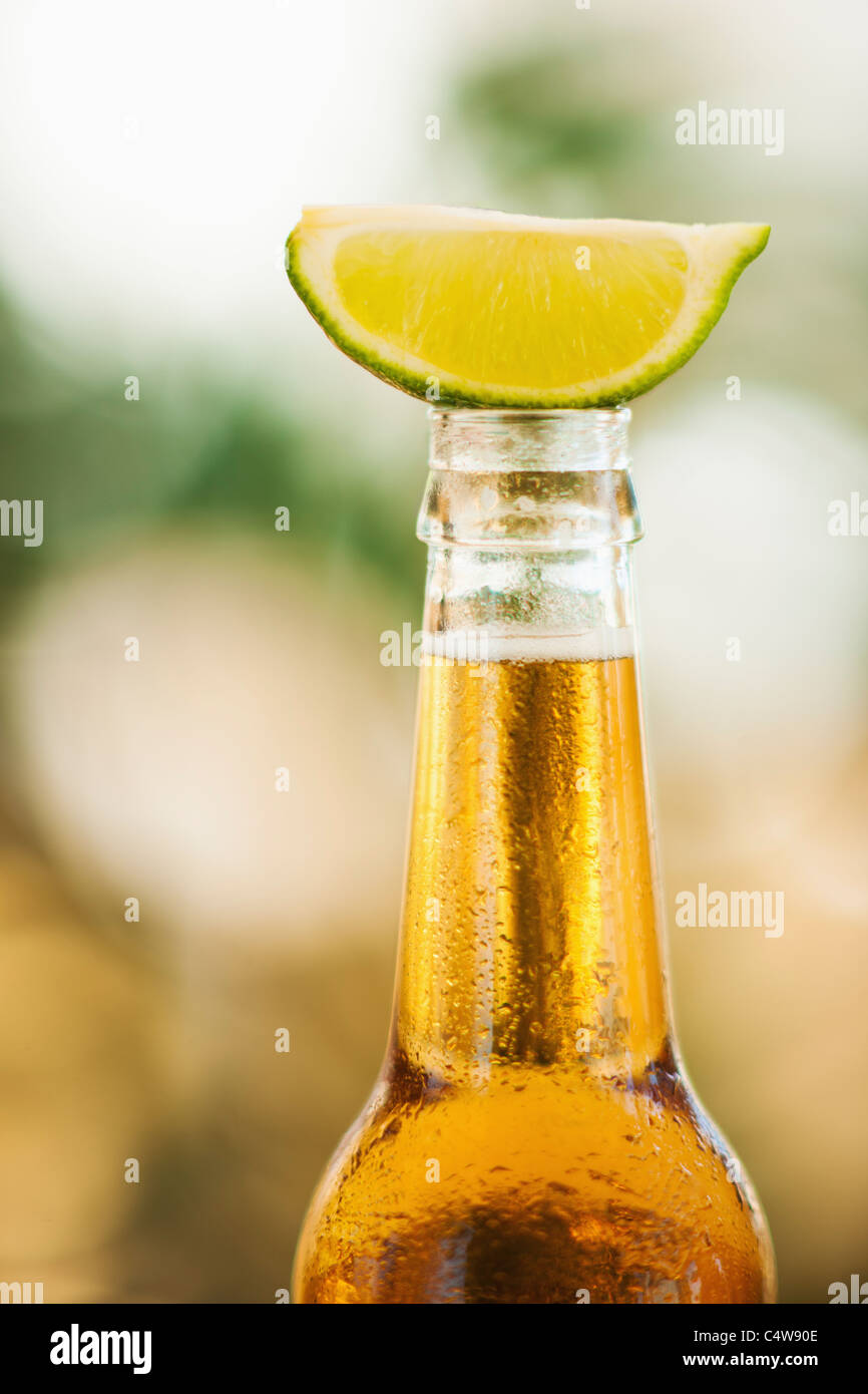 Close up of bottle of beer with lime slice on top Stock Photo - Alamy