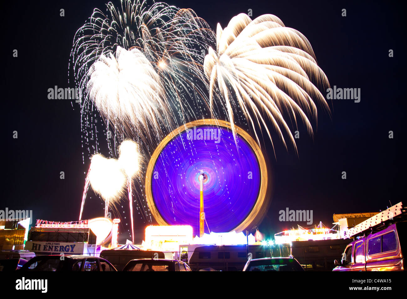 Firework display with illuminated Ferris wheel at night during Cromer ...