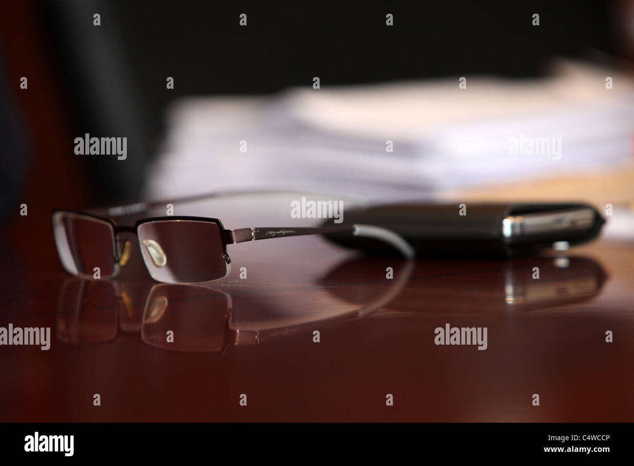 Glasses, mobile phone and paperwork on table Stock Photo - Alamy