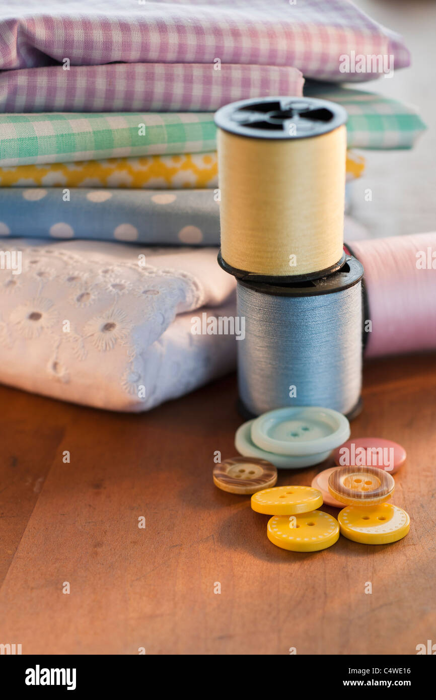 Close-up of thread, buttons and folded textiles Stock Photo - Alamy