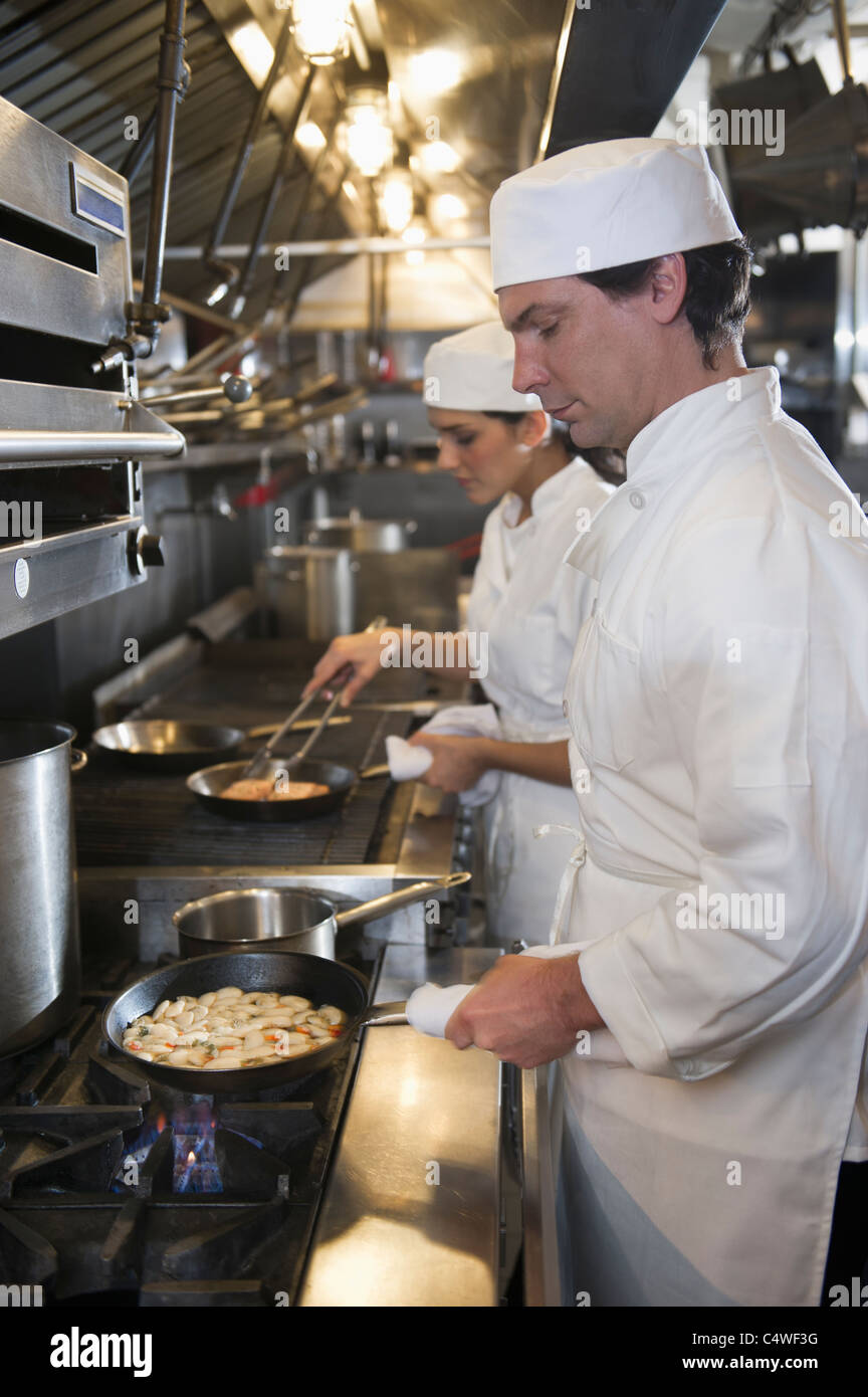 USA, New York, New York City, Chef and cook preparing food in ...