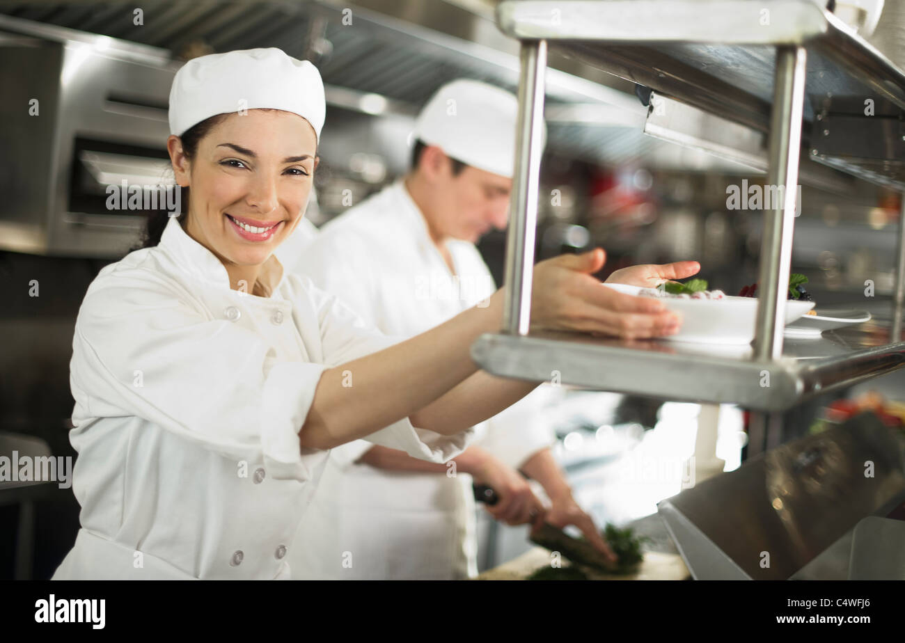 USA, New York State, New York City, Chefs preparing food, woman looking ...
