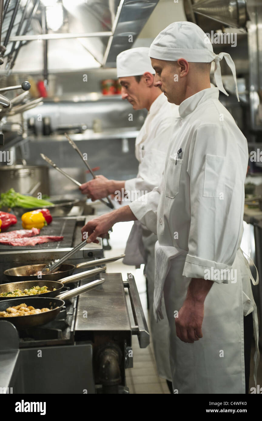 USA, New York State, New York City, Chefs preparing food in kitchen ...