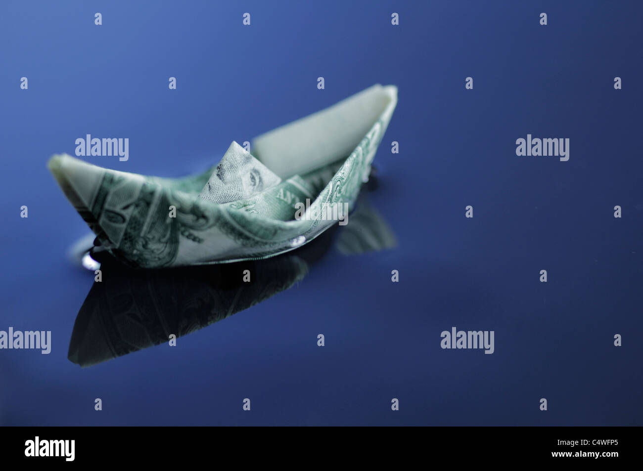 Origami boat made of dollar bill afloat Stock Photo - Alamy