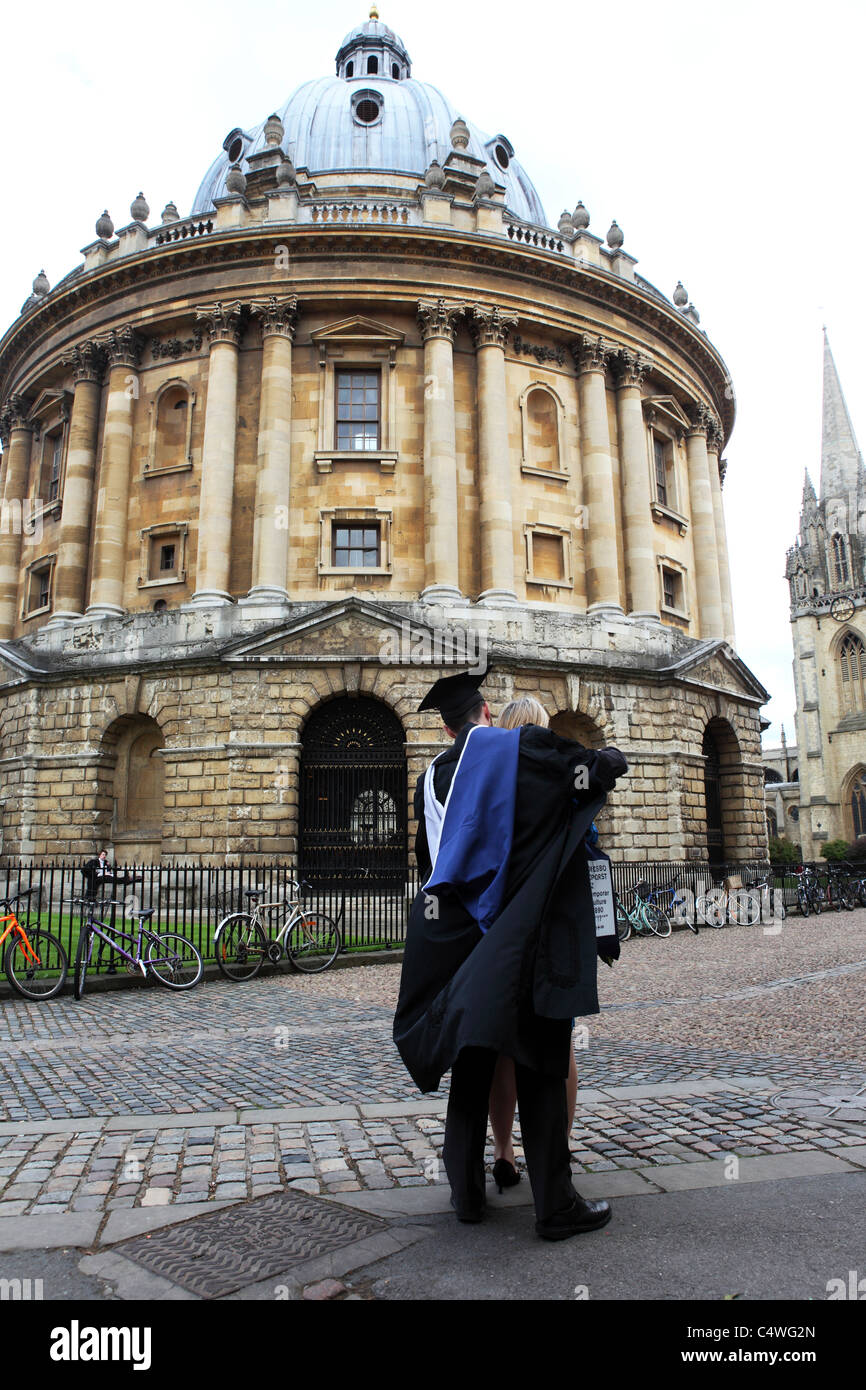 A student in the robes of the University of Oxford stands in front of ...