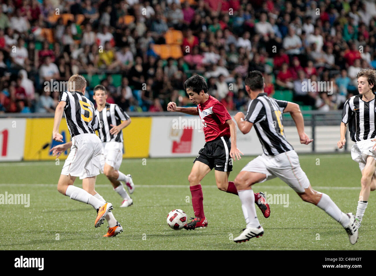 Hazim Hassan of Singapore U16(red) makes a run at the Juventus defence ...