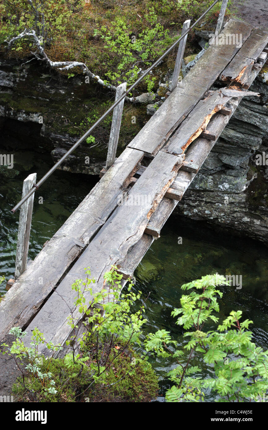 Dangerous old wooden bridge across a river Stock Photo - Alamy