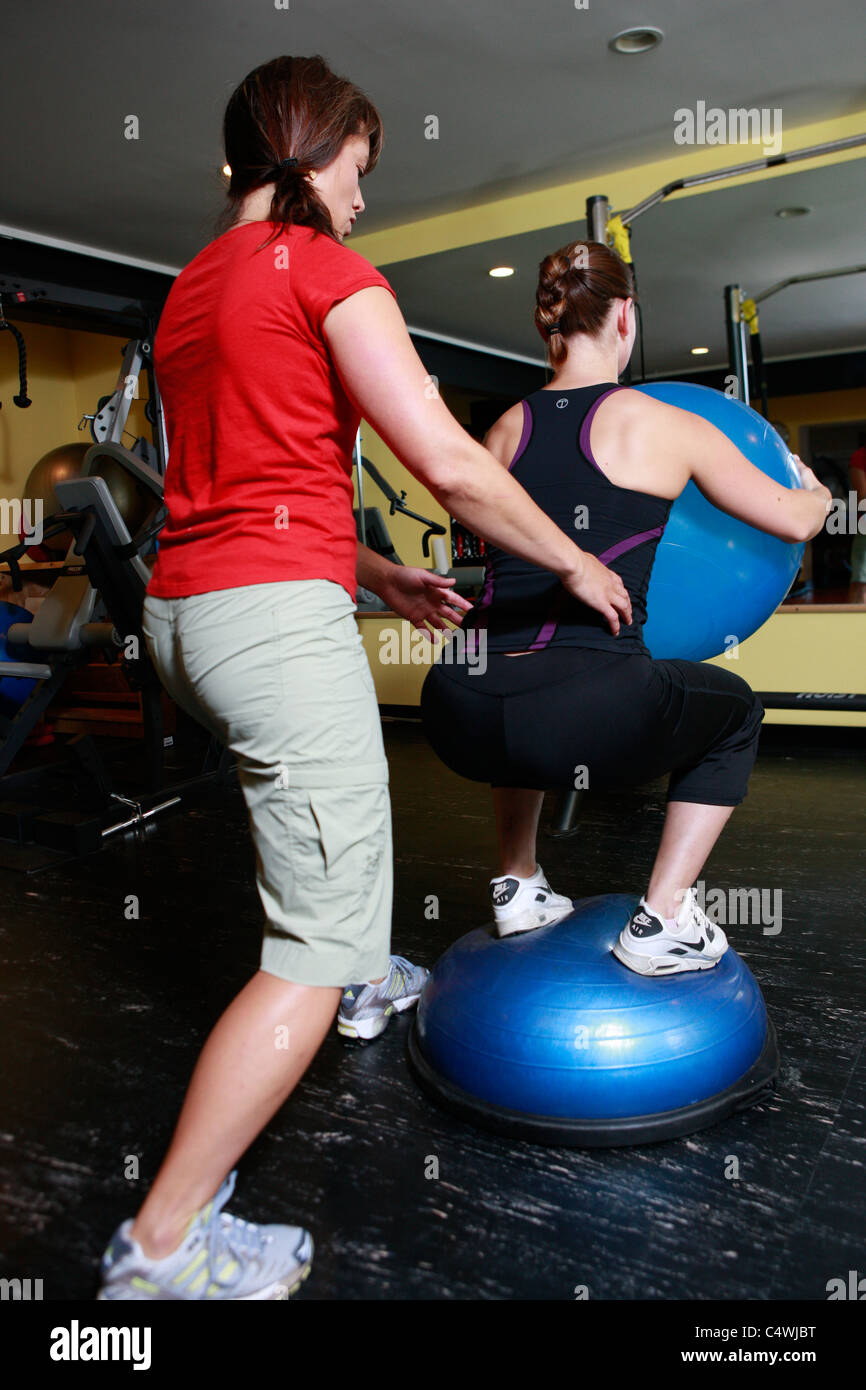 female personal trainer training a man in a gym Stock Photo - Alamy