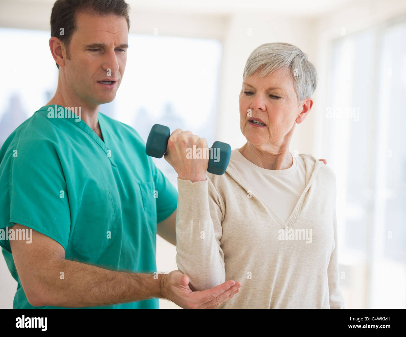 USA, New Jersey, Jersey City, Man assisting senior woman in weight ...