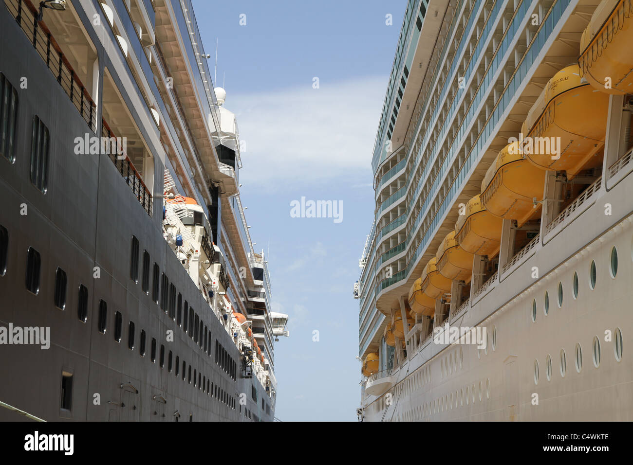Two cruise ships lined up next to each other and docked at the port of ...