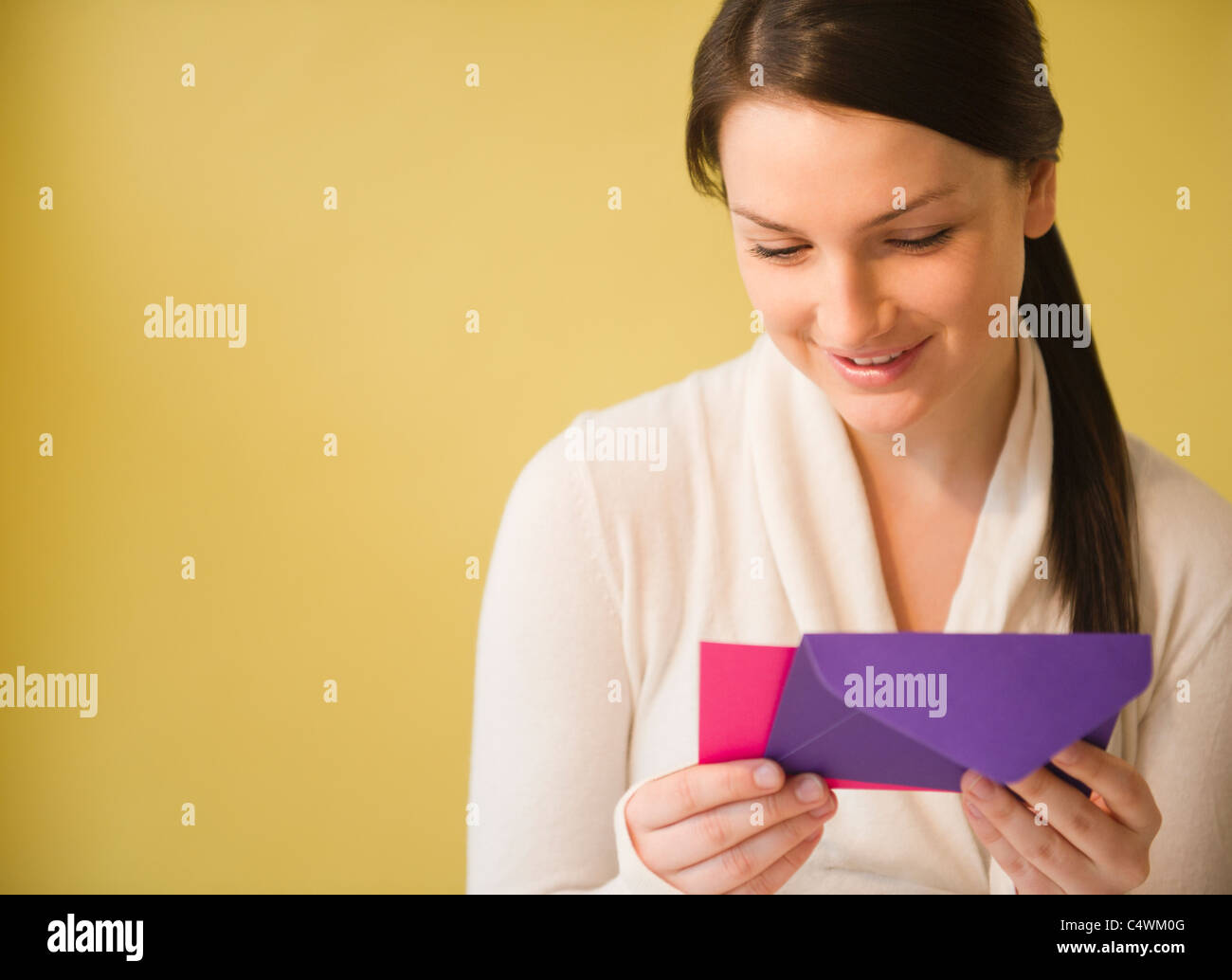 Smiling young woman holding letter Stock Photo - Alamy