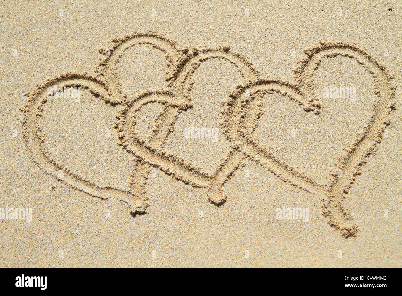 3 Heart Shapes in the Sand Stock Photo - Alamy