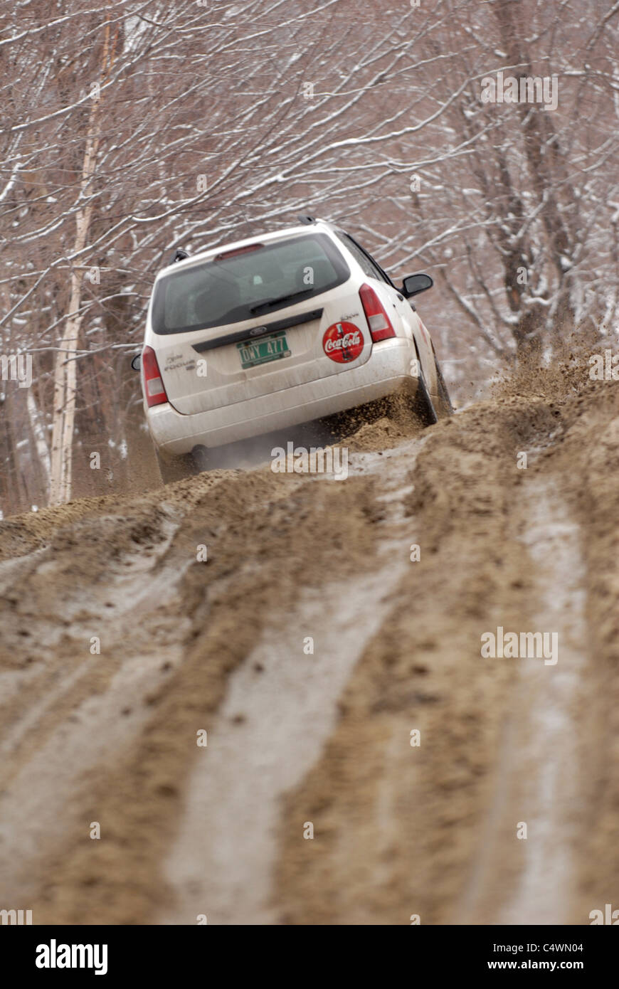 A car makes it’s way along a muddy road during mud season in Vermont in ...