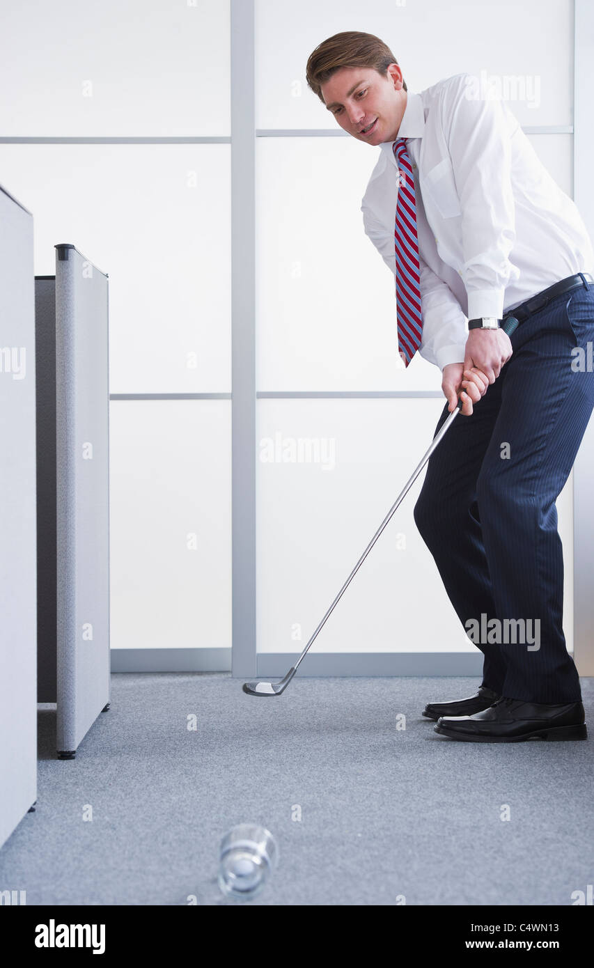 Businessman playing golf in office hi-res stock photography and images ...