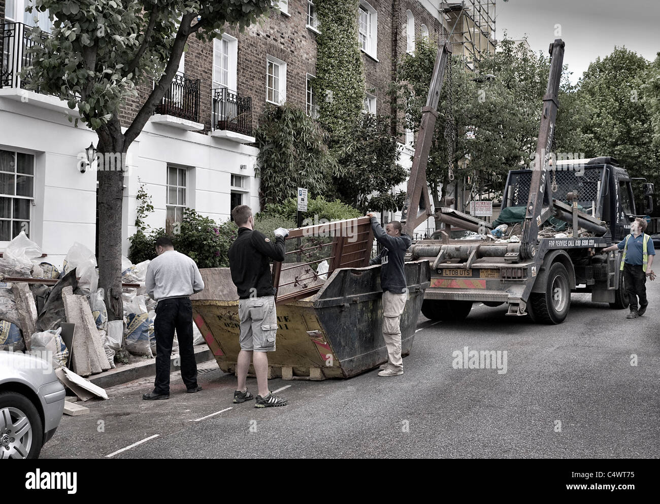 Builders loading a skip Stock Photo - Alamy