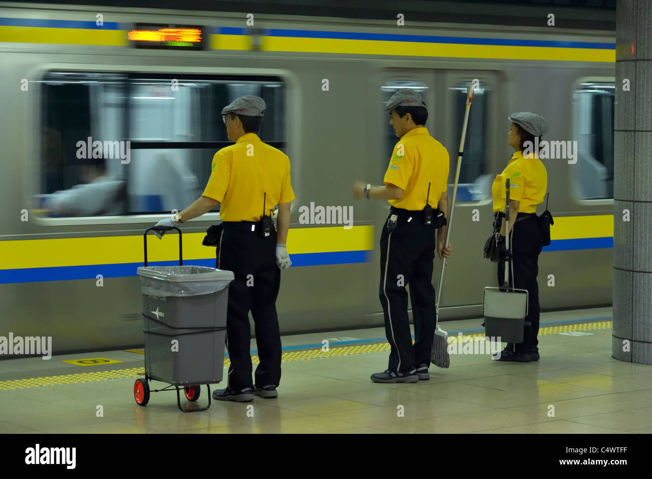 A cleaning team is waiting for the next incoming JR train, Narita ...