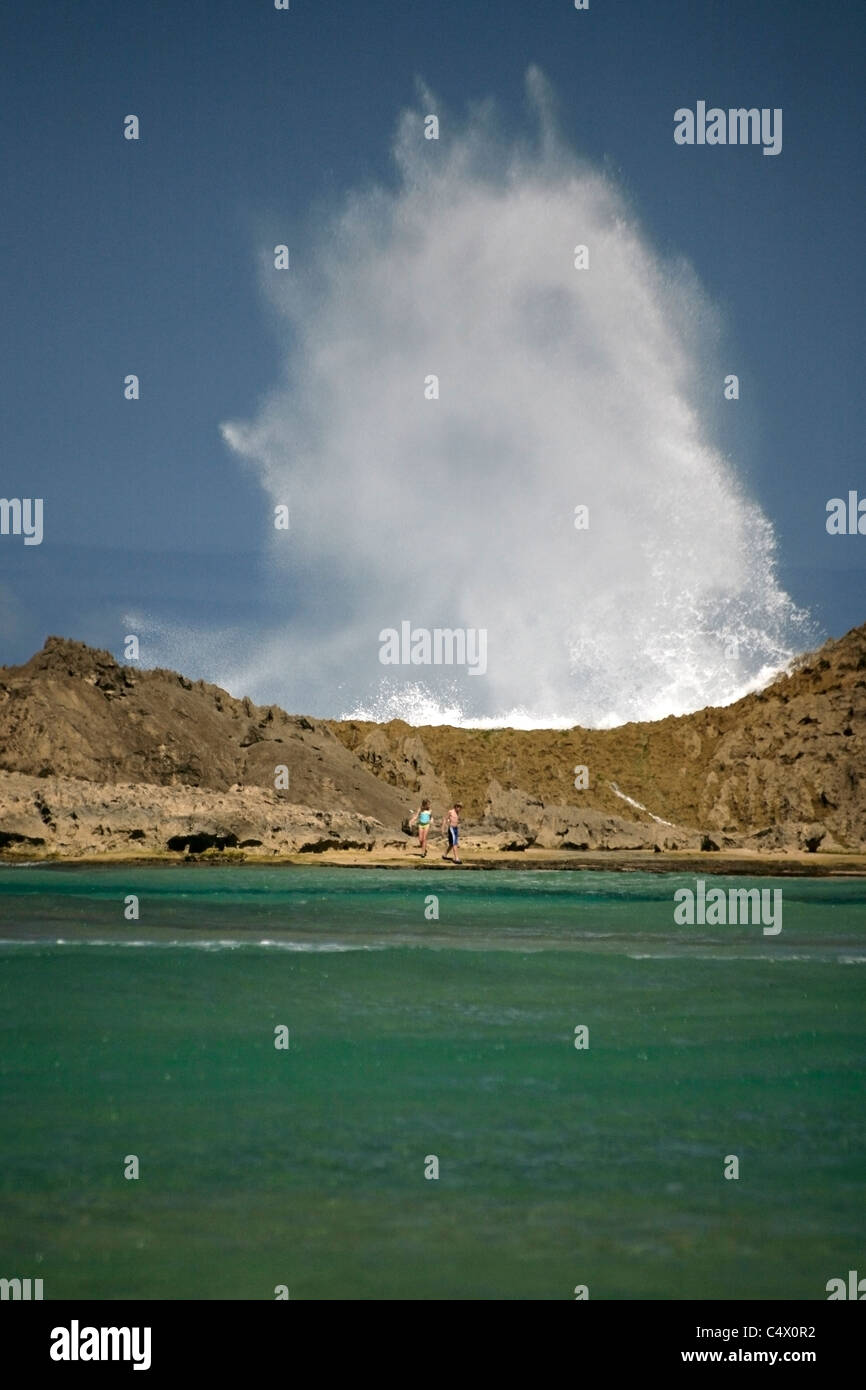 Massive wave breaks on outer reef spraying a boy and girl in Puerto ...