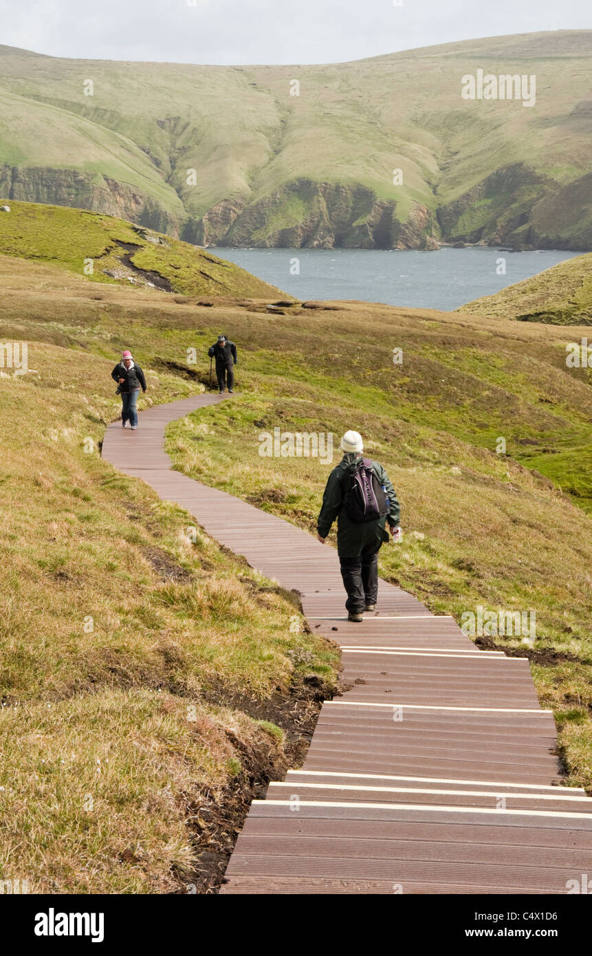 Walkers on path boardwalk made from recycled plastic on Hermaness ...