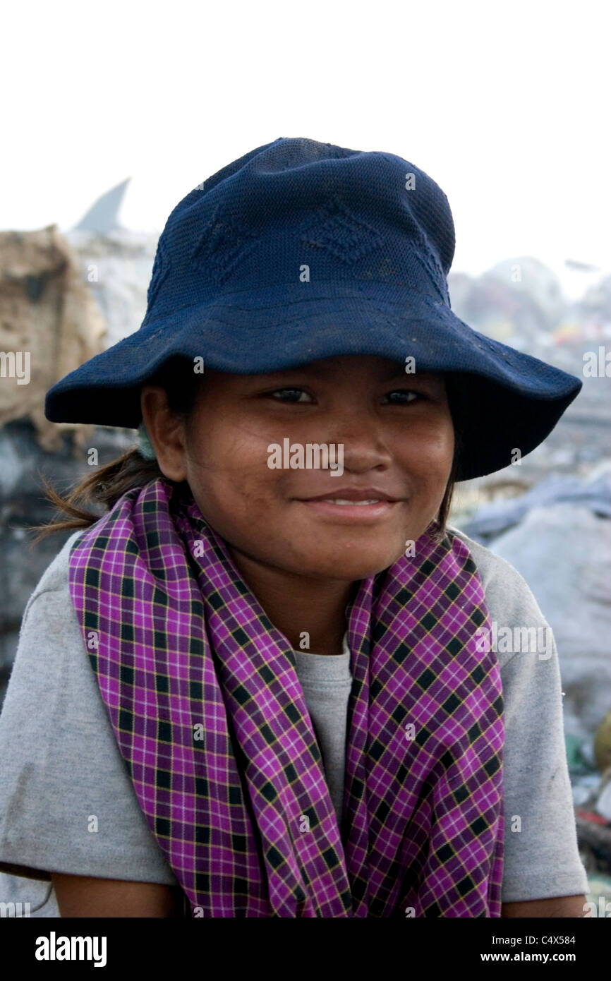 A young child laborer girl living in poverty is searching through ...
