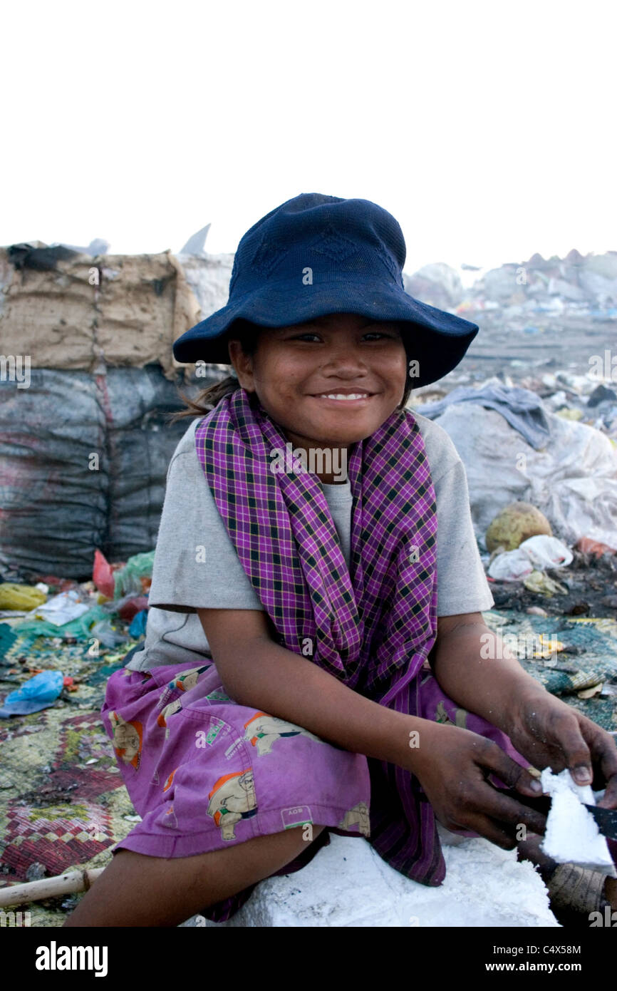 A young child laborer girl is searching through garbage at a polluted ...