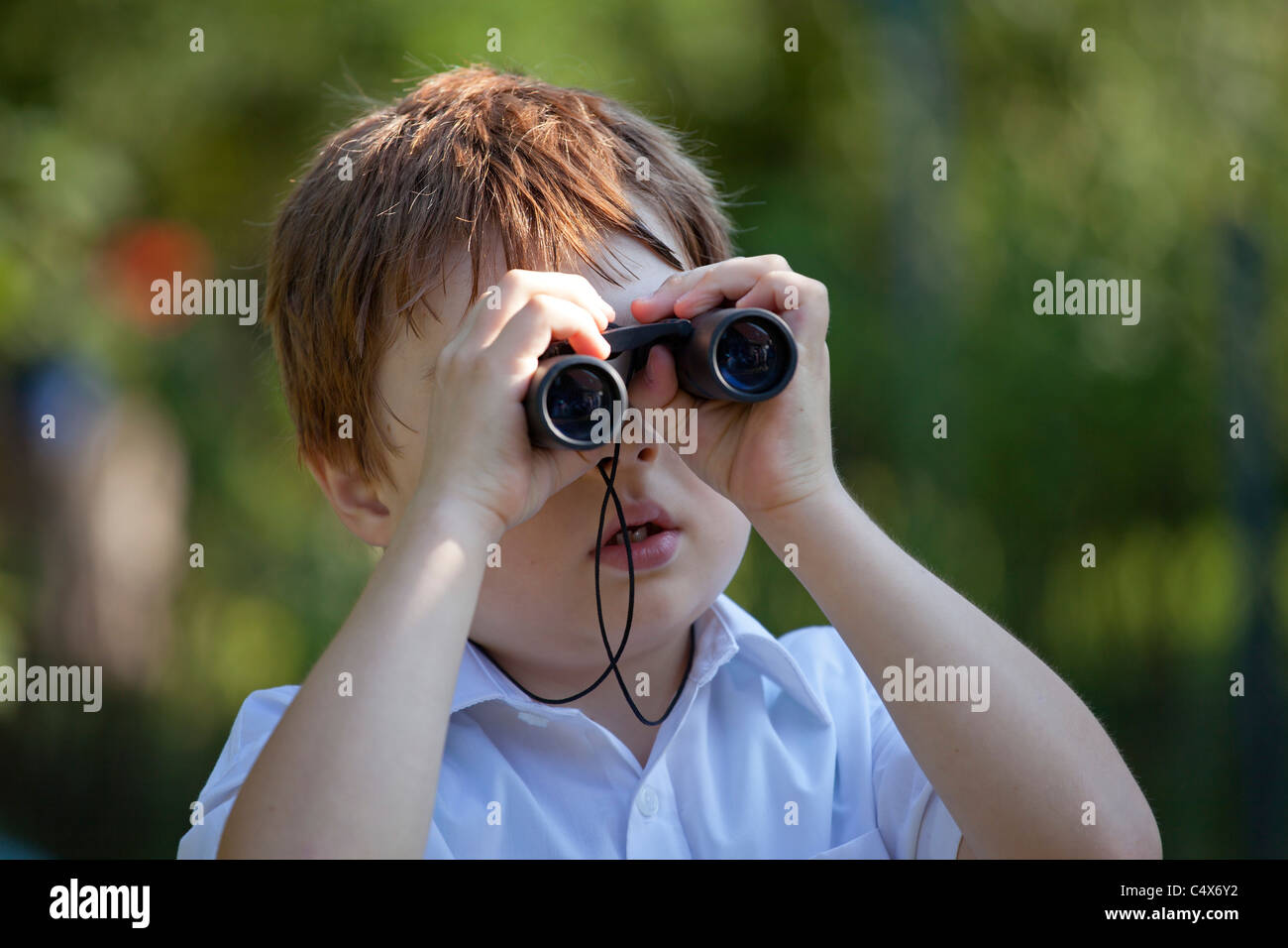 portrait of a young boy looking through binoculars Stock Photo - Alamy