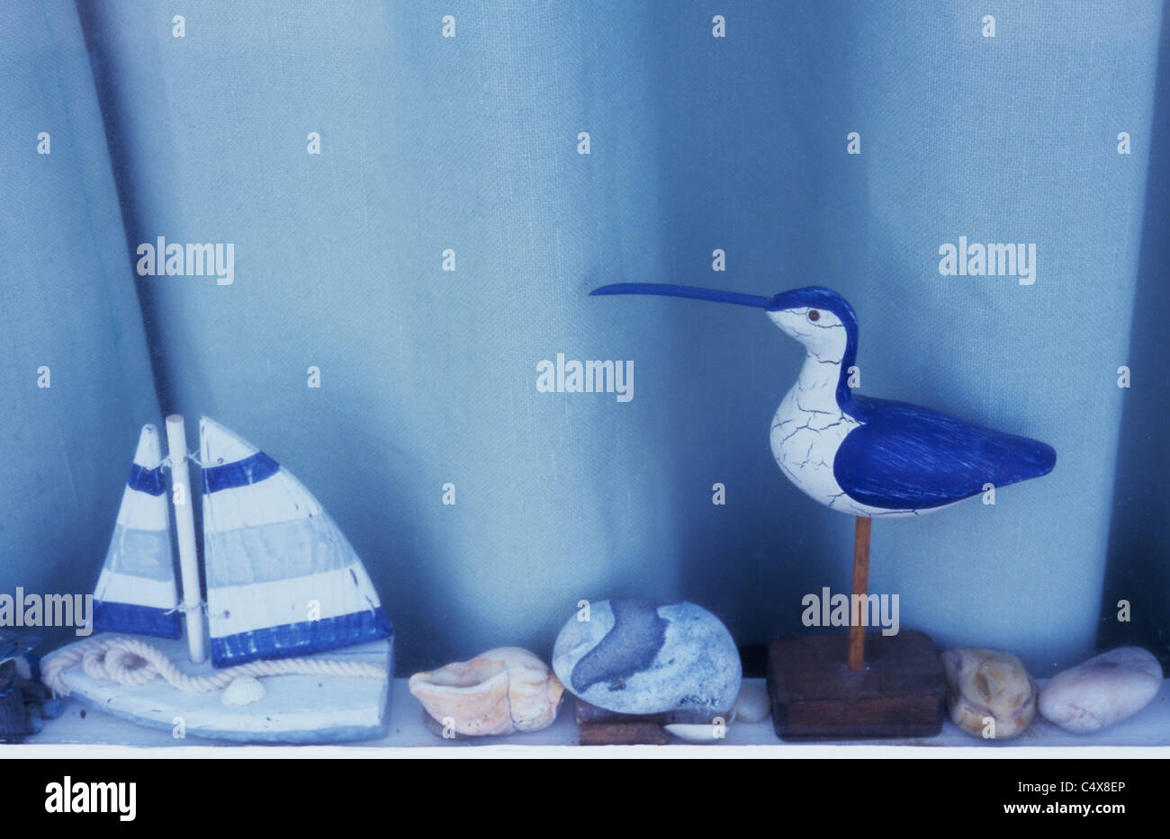 View through window of seaside objects on narrow windowsill with closed ...