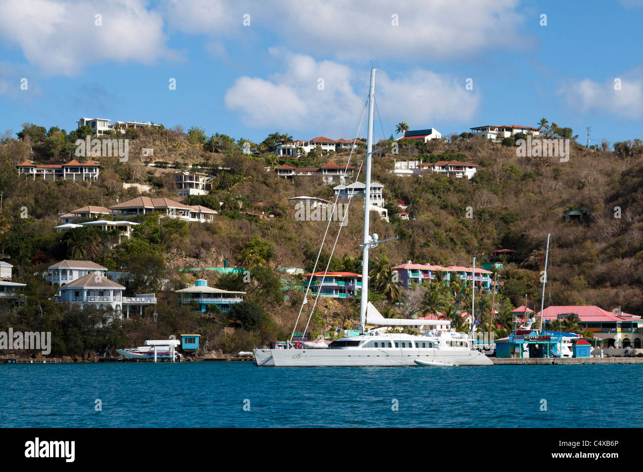 Luxury sailboat docked at Leverick Bay with hillside homes on Virgin ...