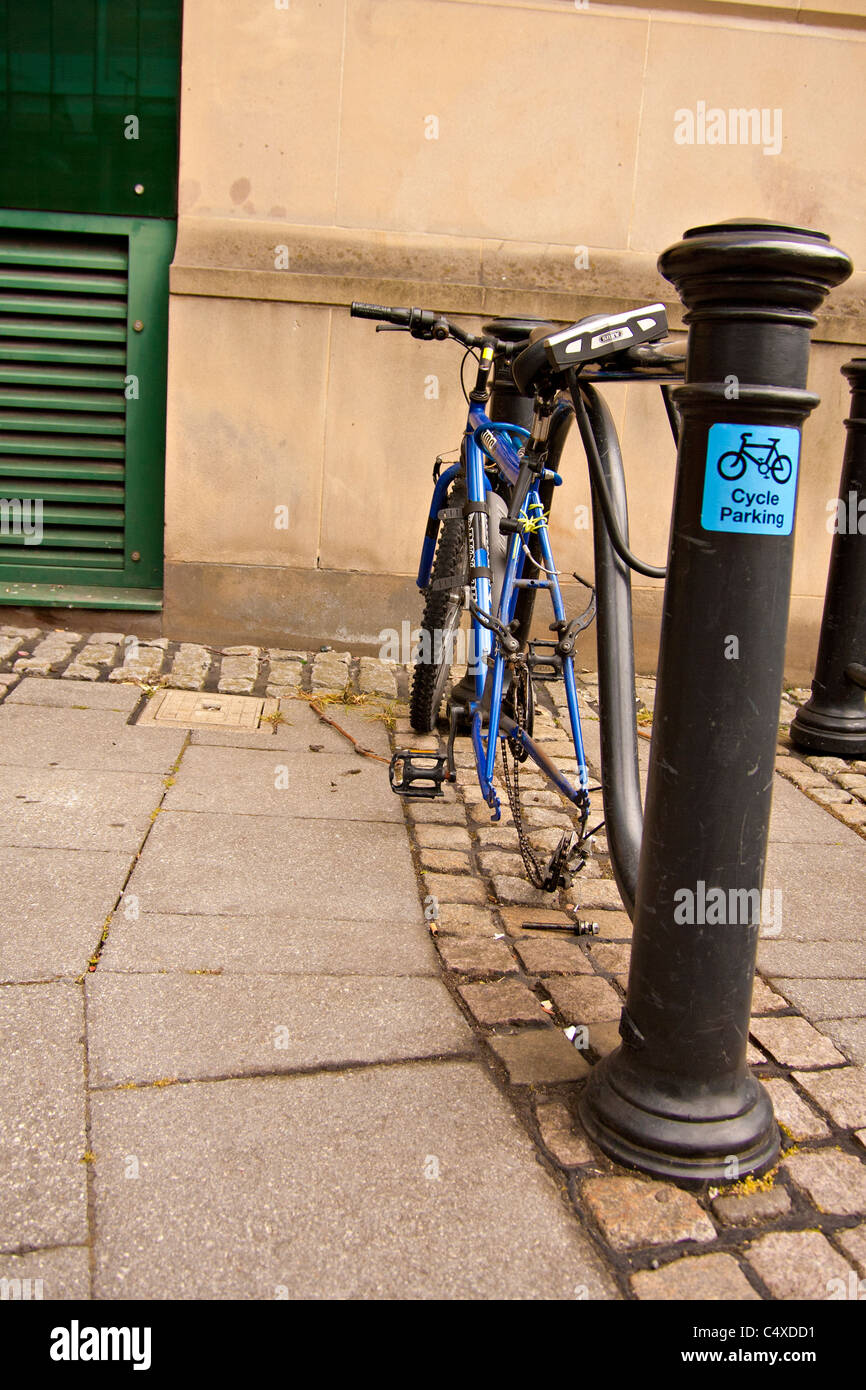 A bicycle without a rear wheel locked at a cycle parking in Newcastle ...