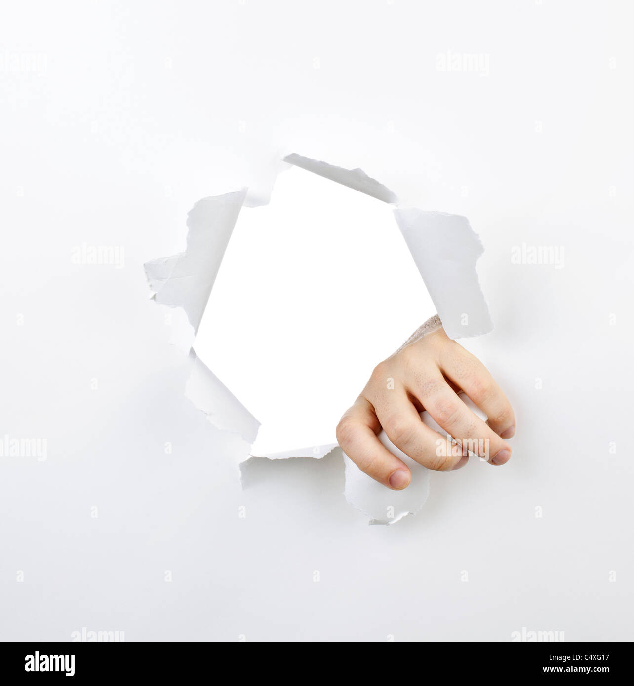 Hand ripping a hole with torn edges in white paper Stock Photo - Alamy