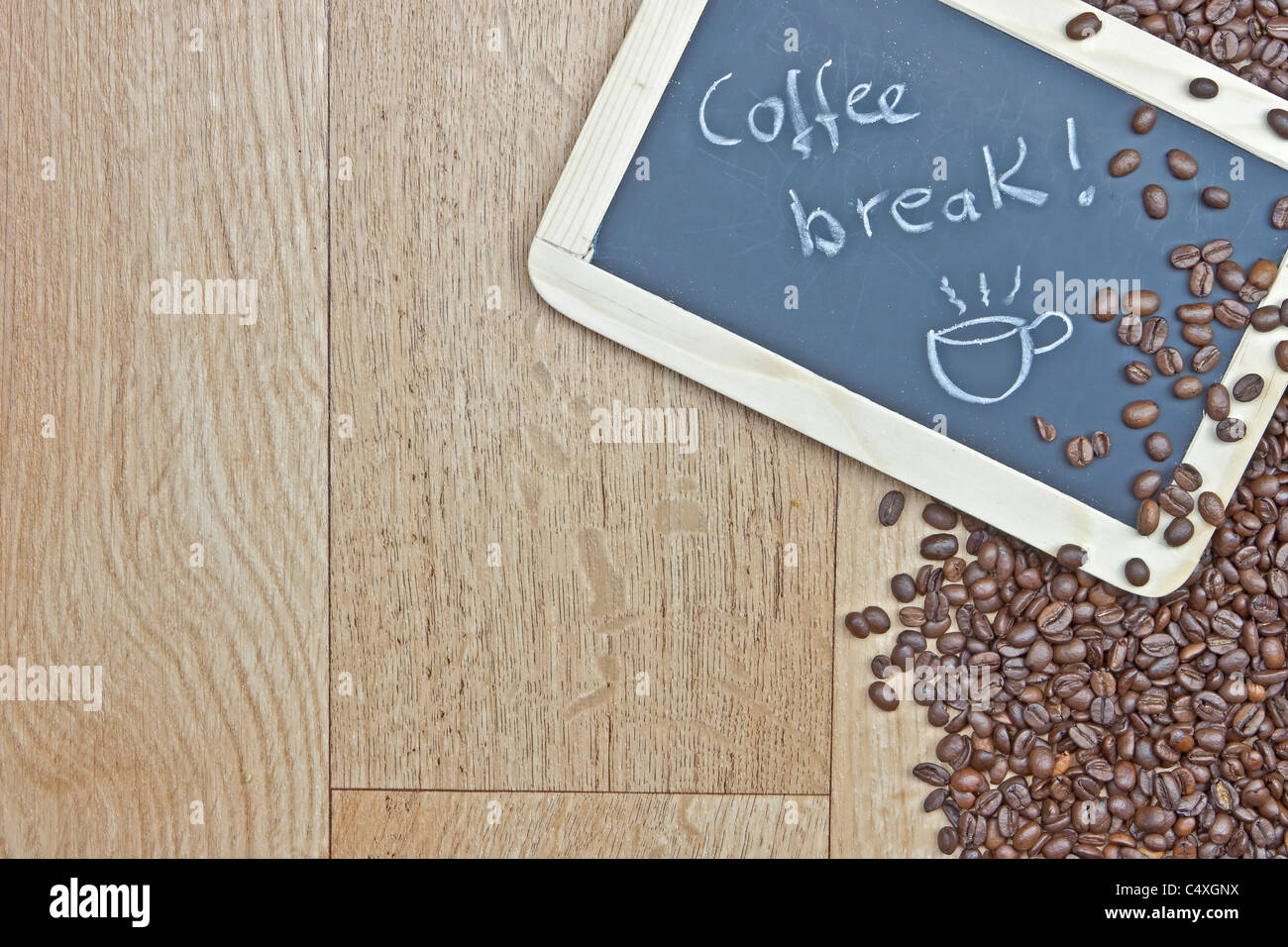 Coffee beans on wood with a chalkboard as a symbol for coffee break ...