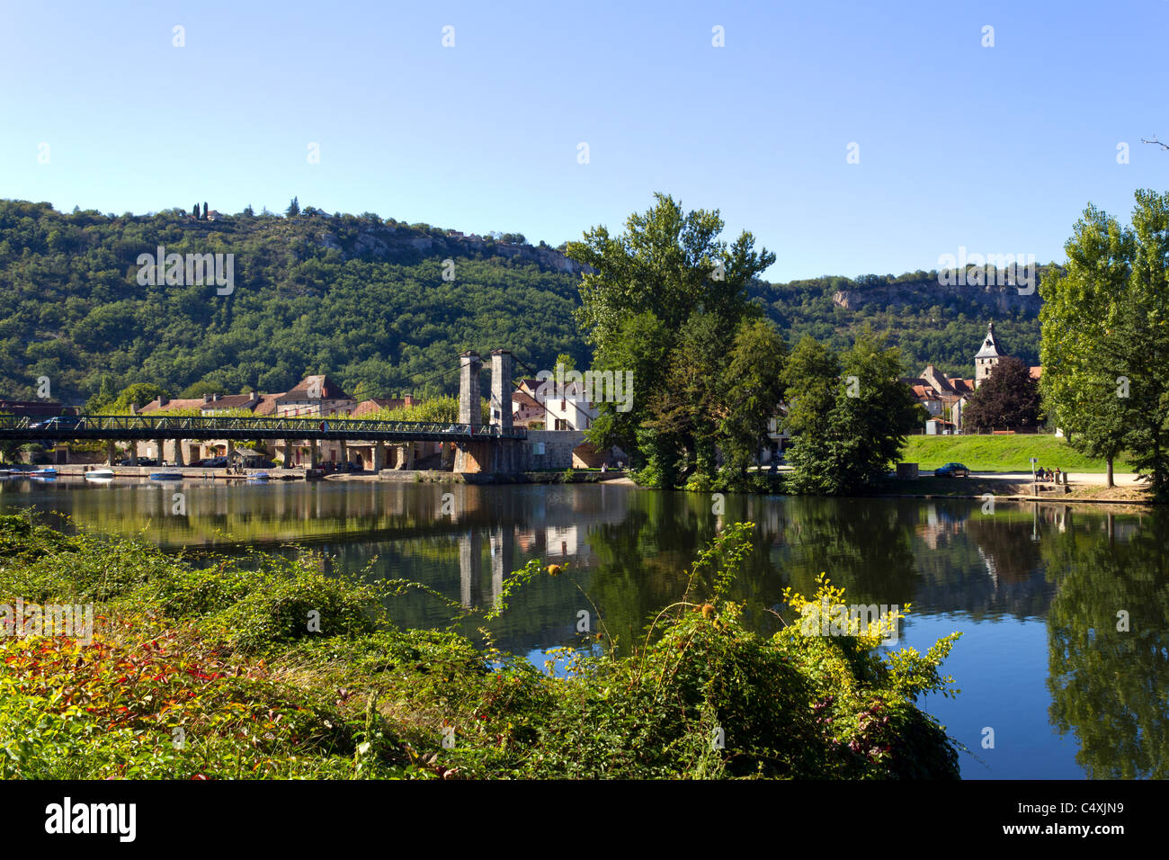 The River Lot and suspension bridge at picturesque Cajarc in the Lot ...