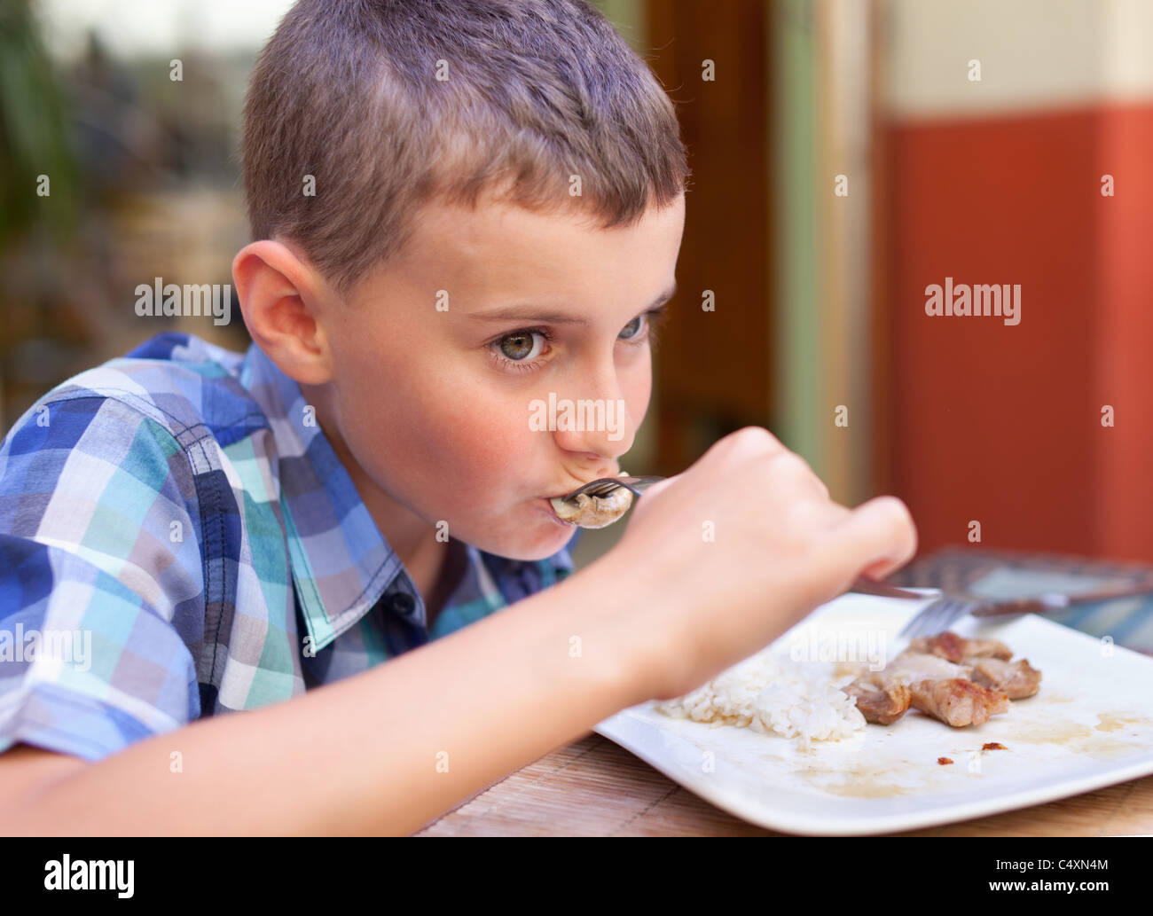 Closeup portrait of a boy eating in a restaurant Stock Photo - Alamy