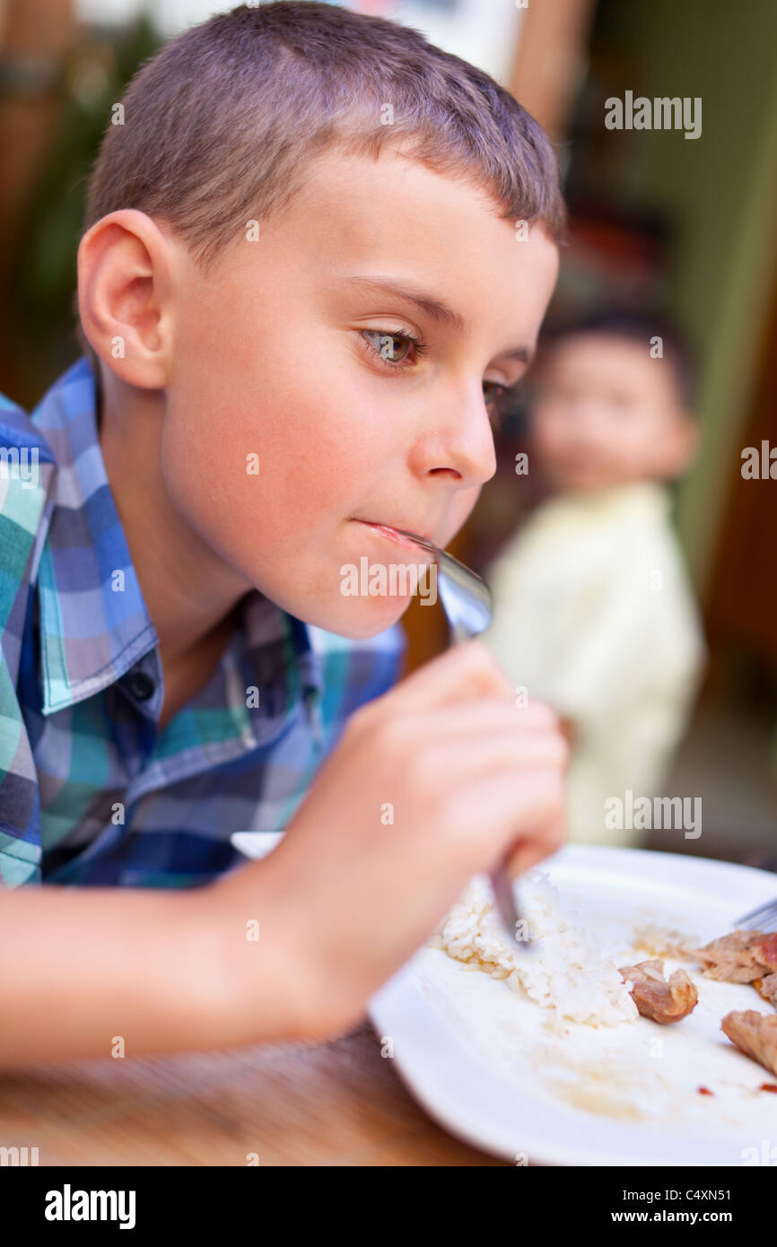 Closeup portrait of a boy eating in a restaurant Stock Photo - Alamy