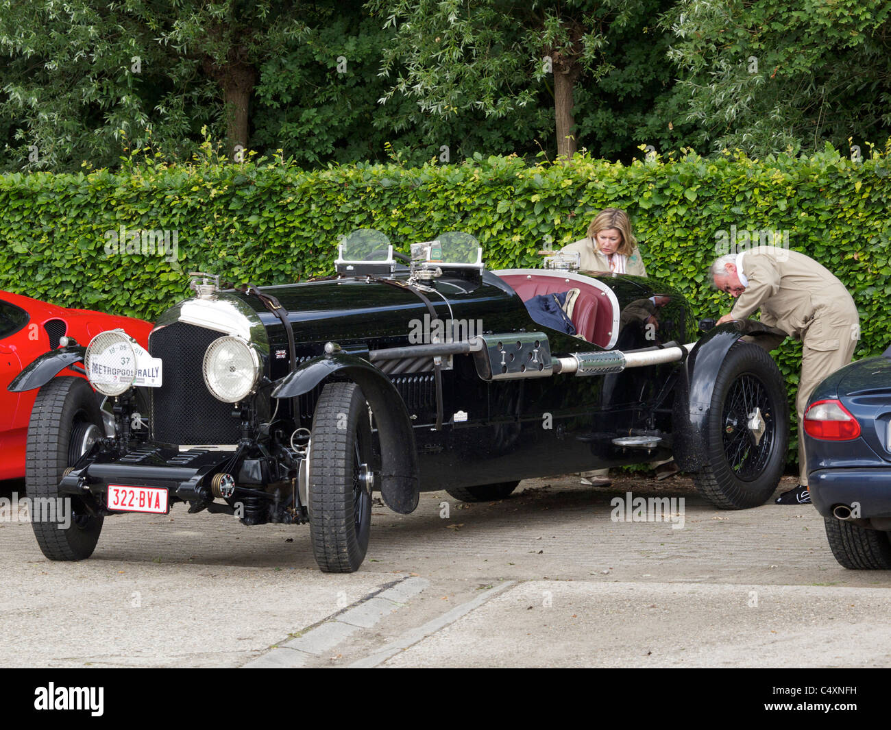 middle-aged couple tending to their 1928 black vintage Bentley racing ...