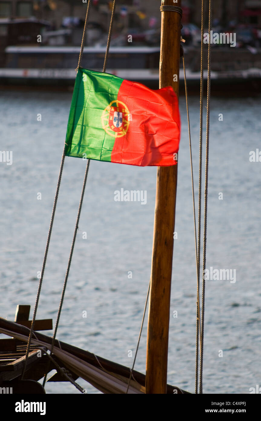 Backlit Portuguese flag flying from the mast of a wine barge, Porto ...