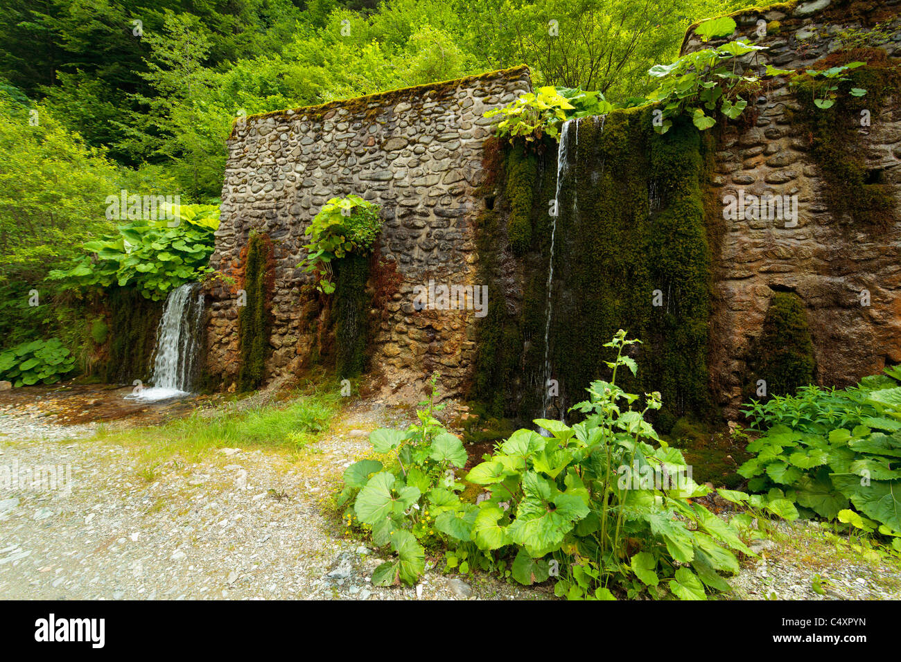 Landscape with an ancient stone wall and water flowing through it Stock ...