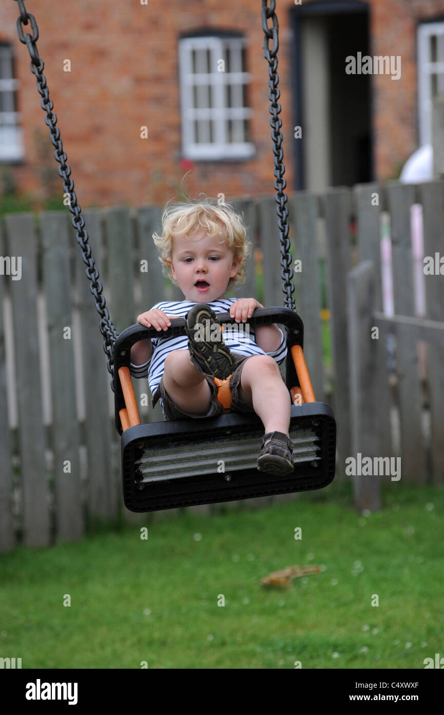 Young boy on swing uk Stock Photo - Alamy
