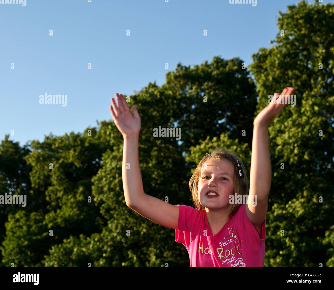 A young girl high on a mans shoulders clapping (hands blurred) during ...
