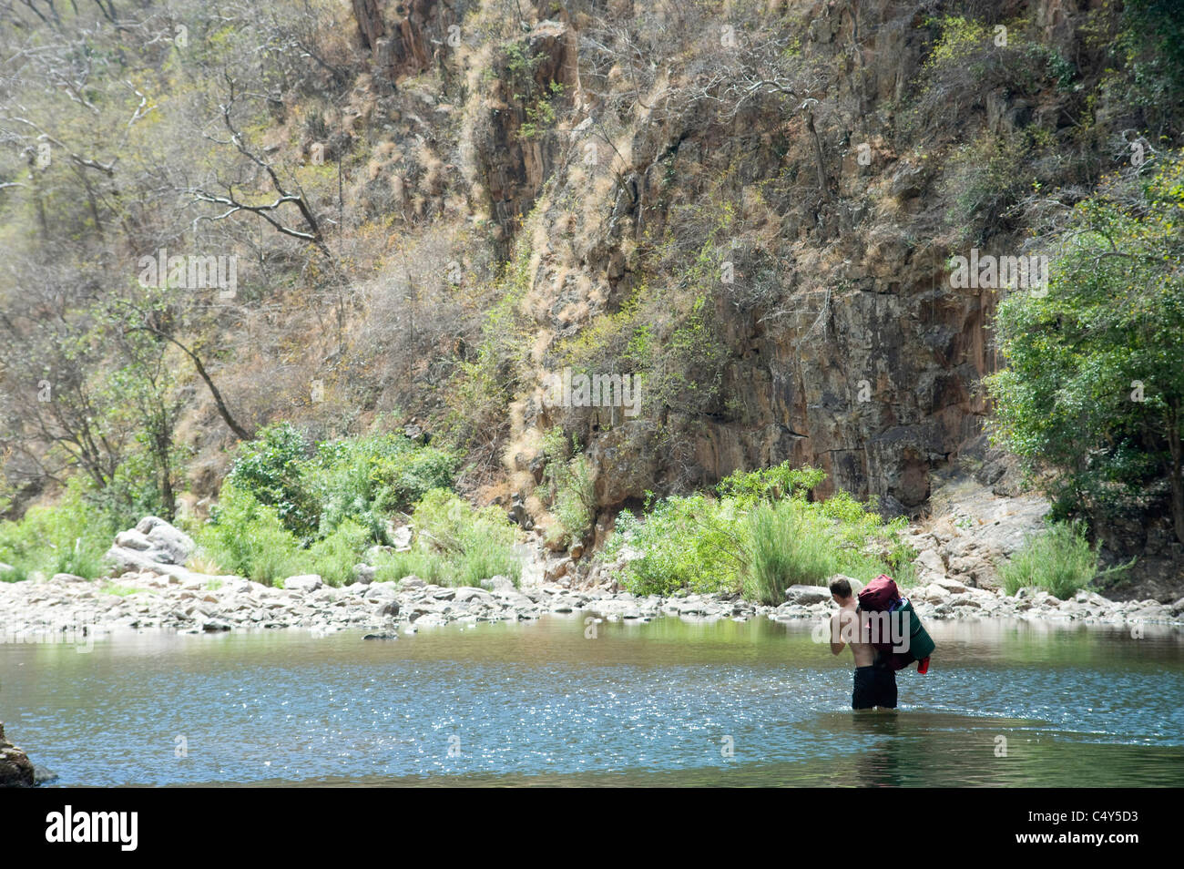 Crossing a deep pool in a gorge in Zimbabwe's Chizarira National Park ...
