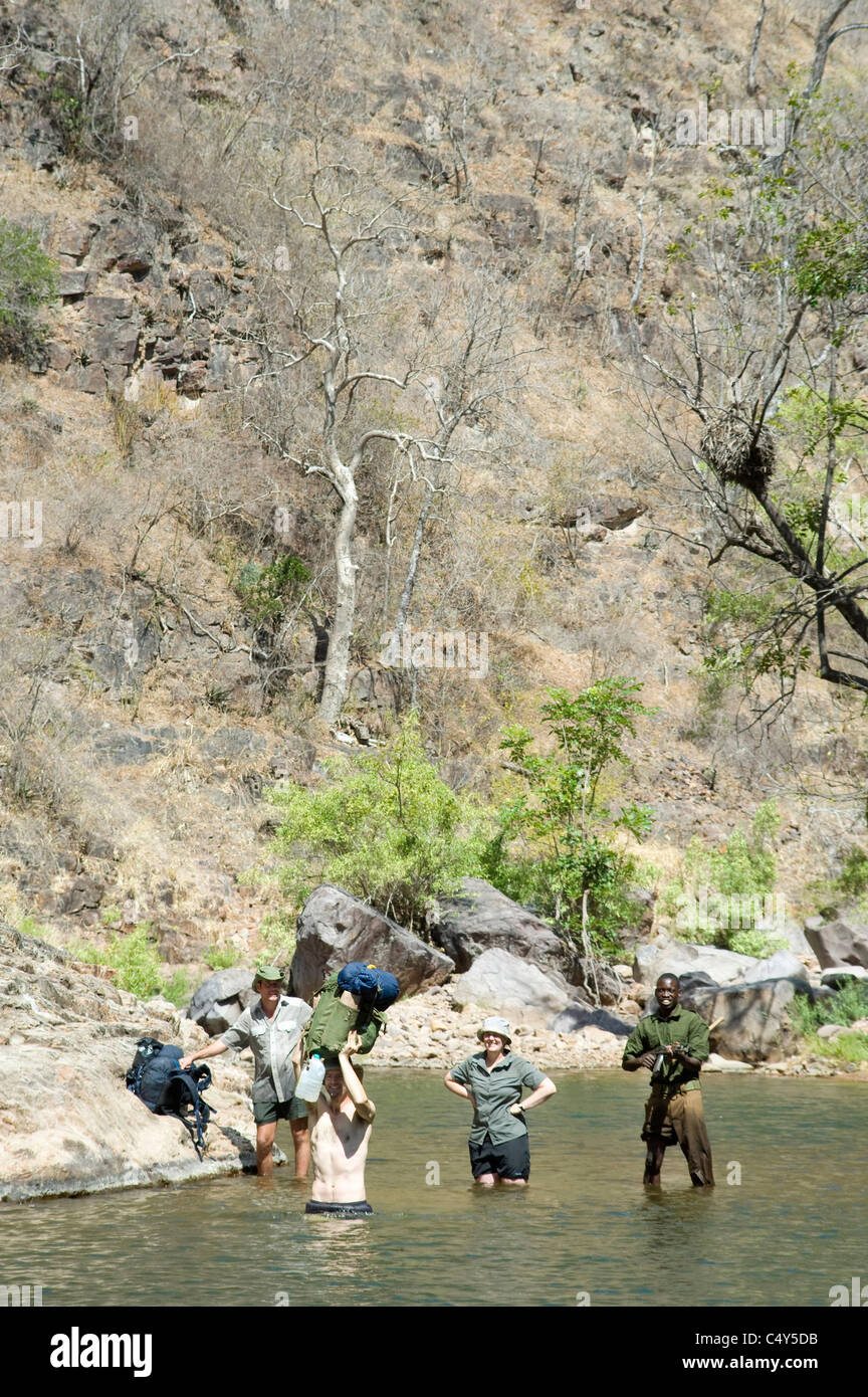 Crossing a deep pool in a gorge in Zimbabwe's Chizarira National Park ...