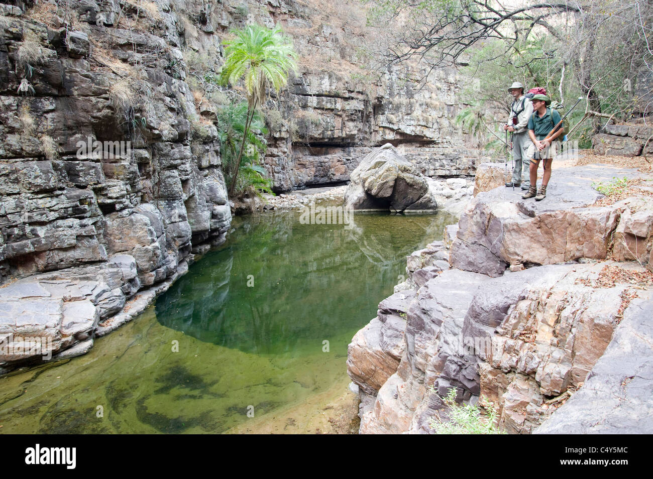 Hikers look at a deep pool along a gorge in Zimbabwe's Chizarira ...