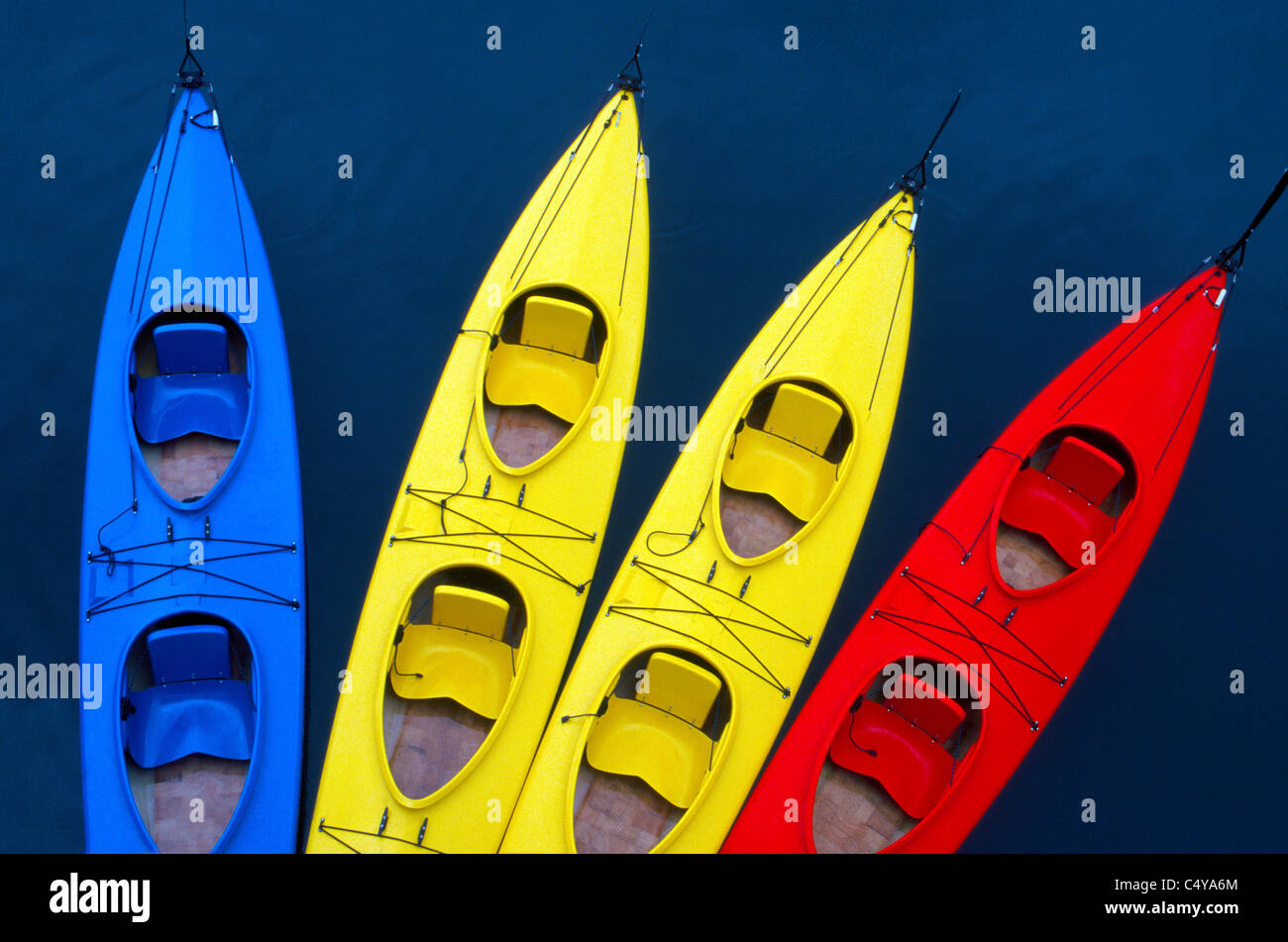 Colorful blue, yellow, and red kayaks await tourists who want to paddle ...